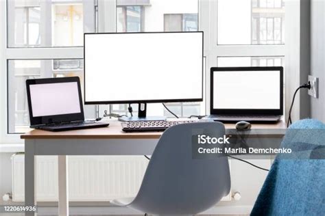 두 개의 노트북과 창 근처에 흰색 모형 빈 화면모니터와 밝은 직장 격리 된 집에서 원격 작업 3가지 개체에 대한 스톡 사진 및