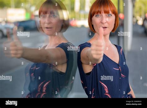 Attractive Enthusiastic Redhead Woman Giving A Thumbs Up Gesture With A Triumphant Smile As She