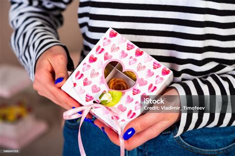 아름다운 손과 긴 손가락을 가진 어린 소녀는 상자에 창 형태로 새겨진 하트인 초콜릿 장미 상자를 들고 있다 개념과 주제에 대한 스톡 사진 및 기타 이미지 Istock