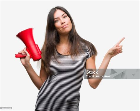 매우 행복 한 측에 손 및 손가락으로 가리키는 확성기를 들고 젊은 히스패닉 여자 가리키기에 대한 스톡 사진 및 기타 이미지 가리키기 감정 긍정적인 감정 표현 Istock
