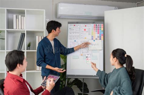 Collaborative Design Session A Team Discusses A Ui Project While Analyzing Relevant Wireframes
