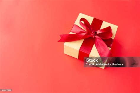 빨간색 장식의 사틴 리본이 있는 빨간색 세련된 스퀘어 베이지 박스와 빨간색 배경에 텍스트 공간이 있습니다 축제 준비 만든 레이아웃 스타일 미니멀리즘 단색 T