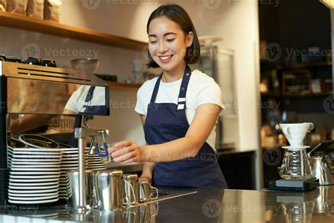 Smiling Girl Barista In Cafe Preparing Cappuccino In Coffee Machine