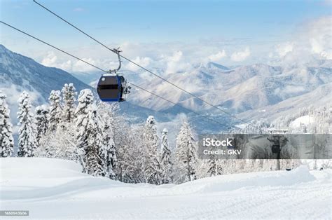 호화로운 겨울 알파인 리조트의 눈 덮인 숲 나무와 눈 덮인 산봉우리를 배경으로 하는 새롭고 현대적인 넓은 대형 오두막 스키 리프트 곤돌라 겨울 레저 스포츠 레크리에이션 및