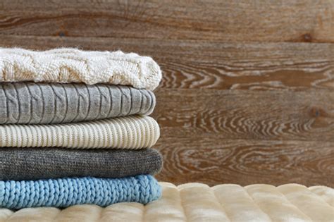 따뜻한 옷에 솜 털 부드러운 양탄자 더미에 놓여 있습니다 나무 바탕에 니트 스웨터입니다 가과 겨울 개념 0명에 대한 스톡 사진