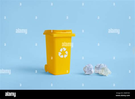 Yellow Container For Paper Garbage Collection And Crumpled Paper
