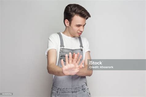 Сonfused 서 무서 워 하 고 그와 차단 터치 하지 묻는 흰색 T셔츠와 데님 바지와 캐주얼 스타일에 젊은 갈색 머리 남자 십대 소년에 대한 스톡 사진 및 기타 이미지