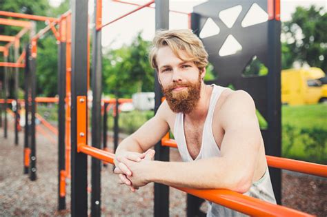 공공 스포츠 그라운드에 서 평행 막대에 훈련 하는 초상화 젊은 수염 남자 잘 생긴 운동 선수 수염을 가진 초상화 스포티 한 남자 훈련 후 휴식 야외 에서 여름 운동 강사에