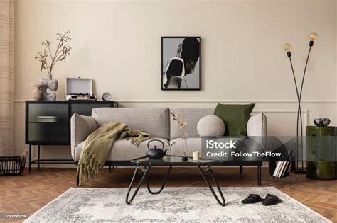 모형 포스터 프레임 회색 소파 검은색 커피 테이블 무늬가 있는 깔개 화분에 있는 식물 슬리퍼 및 개인 액세서리가 있는 거실 인테리어의 창의적인 구성 가정 장식 템플렛 0명에