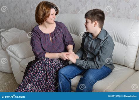 Mother And Son Hold Hands And Look At Each Other Stock Photo Image Of Couch Smiling