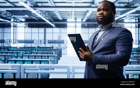 Programmer In Server Room Location Using Tablet To Patch Network Issues Affecting Transfer Rates