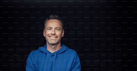 팔짱을 끼고 어두운 배경의 스튜디오에 서서 카메라를 바라보는 행복한 성숙한 남자의 초상화 사진 Unsplash의 슬로바키아 이미지