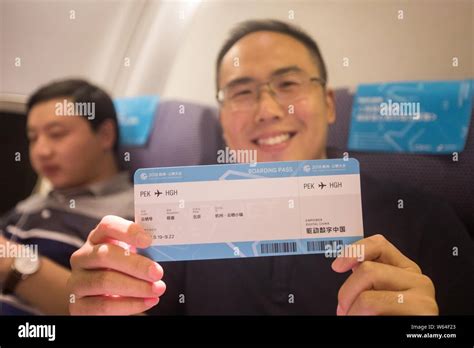 A Chinese Passenger Shows His Boarding Pass Onboard Flight Cz6163 From Beijing To Hangzhou Which