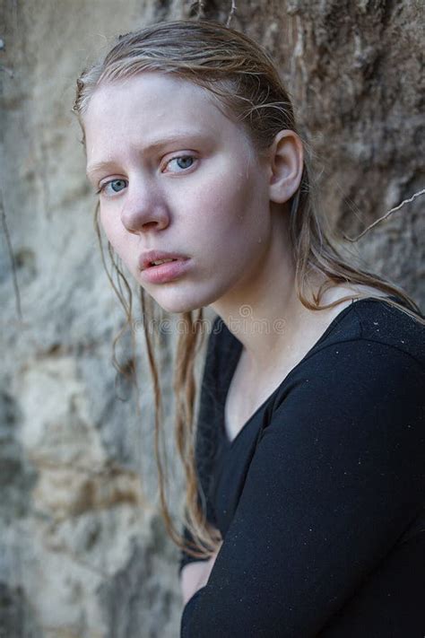 Portrait Of Young Girl In Black Dress With Wet Long Blonde Hair Posing