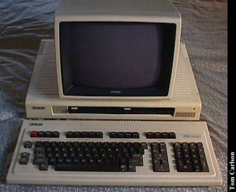 An Old Computer Sitting On Top Of A Bed Next To A Small Keyboard And Mouse