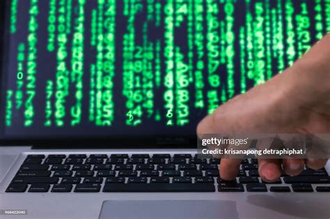 Hacker Using Laptop Lots Of Digits On The Computer Screen High Res