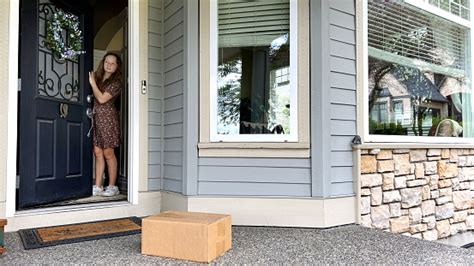 비디오 소녀가 문 근처의 상자를 볼 때 외출하고 배달원이 보이지 않는 그녀를 데려온 사람을 둘러 보며 혼자 접근하여 상자를 가져 와서 집으로 돌아옵니다 고객에 대한 스톡