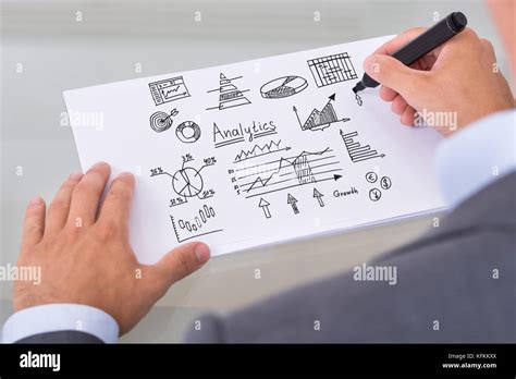 Cropped Image Of Businessman Preparing Analytical Diagrams At Table In Cropped Image Of Businessman Preparing Analytical Diagrams At Table In
