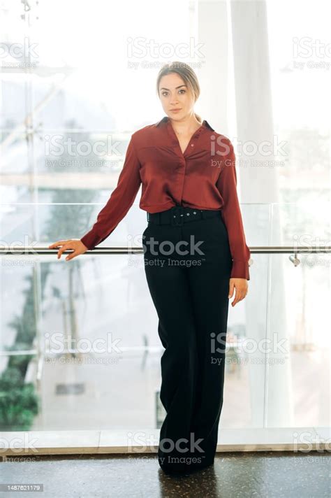 우아한 옷을 입고 비즈니스 센터에 서서 포즈를 취하고 카메라를 바라보는 아름다운 성공적인 자신감 있는 금발의 백인 비즈니스 레이디의 세로 전체 길이 사진 30 34세에 대한