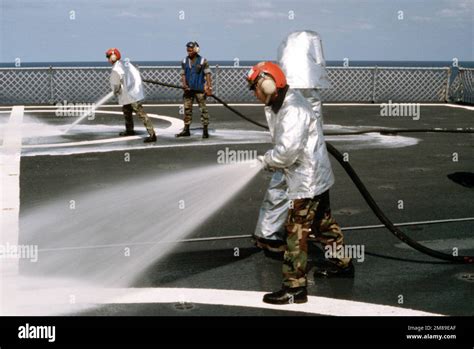 Marines In Proximity Suits Hose Down The Flight Deck Of The Aviation Logistic Ship Usns Wright