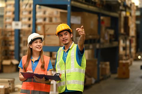 안전모와 반사 재킷을 입은 두 명의 창고 직원이 소매 창고의 높은 선반 사이에 서 있습니다 25 29세에 대한 스톡 사진 및 기타 이미지 Istock