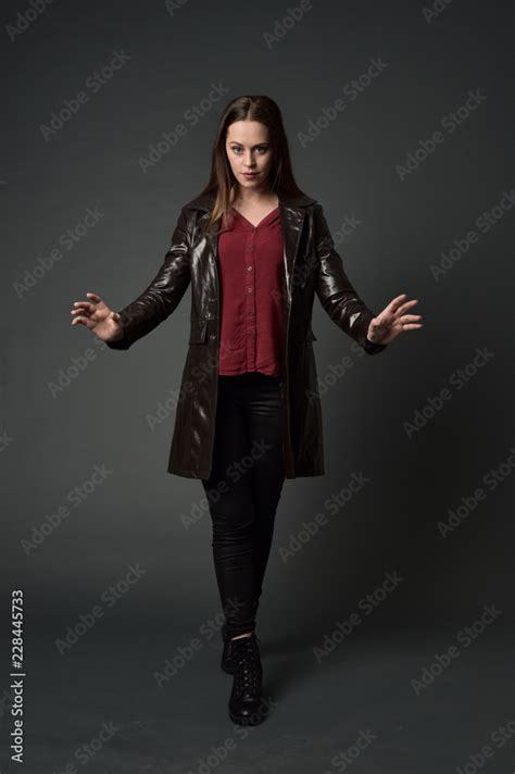 Full Length Portrait Of Brunette Girl Wearing Long Leather Coat And