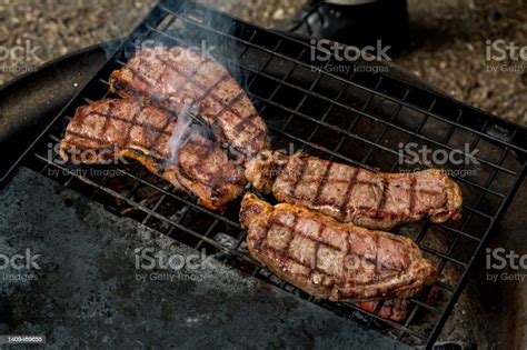 캠프 파이어에서 주철 그릴 접시에 굽는 쇠고기 스테이크 캠프 파이어 요리 야외 바베큐 고기에 대한 스톡 사진 및 기타 이미지 고기 구이 굽기 Istock