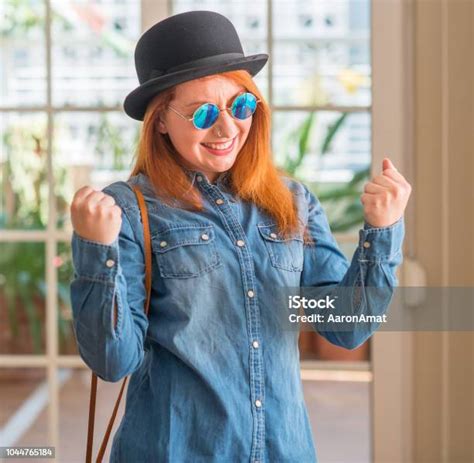 세련 된 빨간 머리 여자 선글라스 매우 행복 하 고 흥분 무기와 우승자 제스처를 하 고 중산 모자를 입고 웃 고 성공을 위한 비명 축 하 개념입니다 귀여운에 대한 스톡 사진