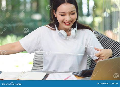 Asian Woman Babe Sitting At The Table In Living Room Using Computer Laptop When Studying