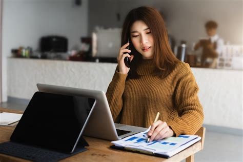 Premium Photo Women Working Laptop Computer And Holding Smartphone With Coffee Cup On Table In