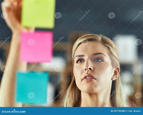 woman writing and sticky notes on glass for project ideas planning and schedule management of