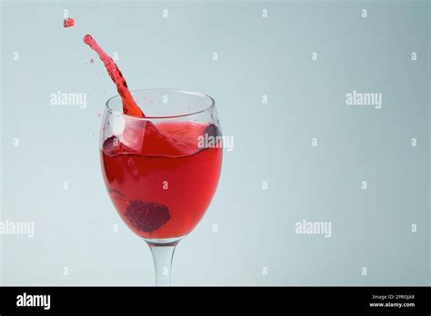 Raspberry Splashing Into Glass Of Wine Red Juice Drink Splash Water Drop On White Background
