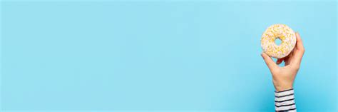 여성의 손은 파란색 배경에 도넛을 보유하고 있습니다 컨셉 제과 점 페이스트리 커피숍 기치 플랫 레이 상단 보기 도넛에 대한 스톡 사진 및 기타 이미지 Istock