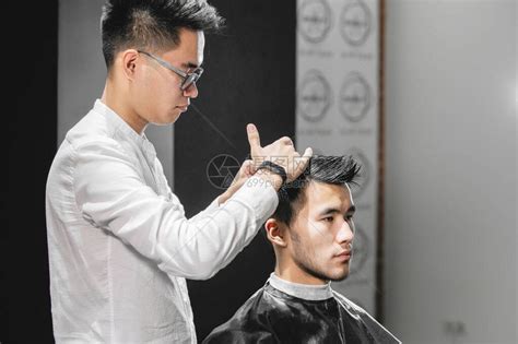 年轻理发师在美容院里给男高清图片下载 正版图片504596517 摄图网