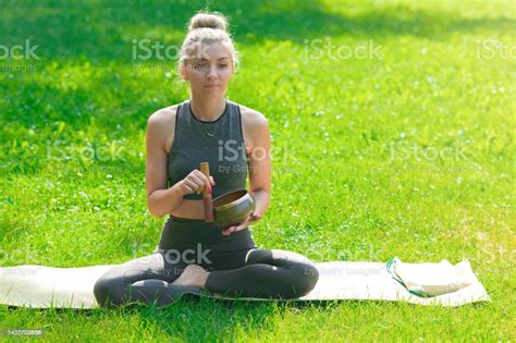여름에 공원의 푸른 풀밭에 앉아있는 한 여성이 명상 그릇을 들고 있습니다 30 39세에 대한 스톡 사진 및 기타 이미지 30 39세 35 39세 강사 Istock