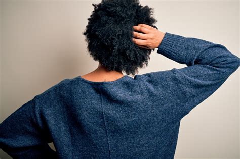 젊은 아름다운 아프리카 계 미국인 Afro 여자 곱슬 머리 캐주얼 스웨터를 입고 뒤로 머리에 손으로 의심에 대해 생각 곱슬