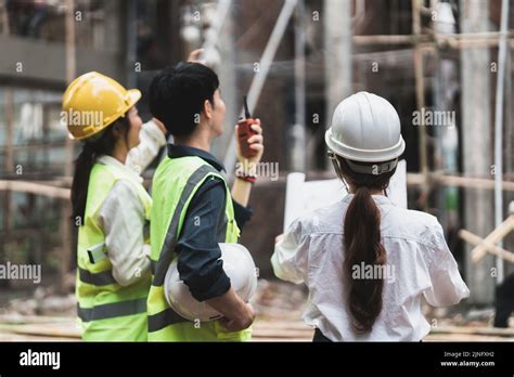 Engineering And Construction Managers Discussing Project Blue Print On The Table At Construction