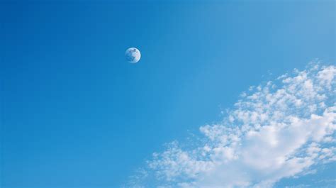 Daytime S Delight A Vibrant Blue Sky Embracing The Moon Background