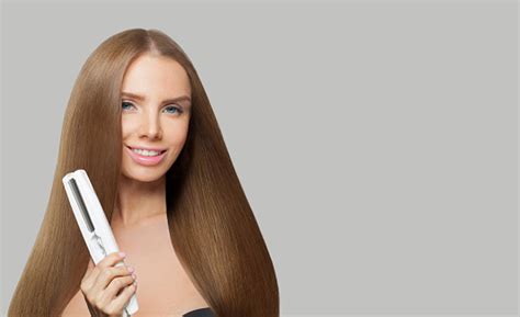 흰색 배경에 철을 곧게 펴는 긴 스트레이트 건강한 헤어 스타일을 가진 웃는 여자의 스튜디오 초상화 뷰티 헤어 케어 헤어 트리트먼트 및 화장품 컨셉 25 29세에 대한 스톡