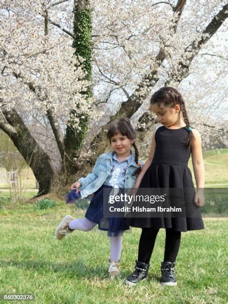 Two Girls Playing Under A Tree Photos And Premium High Res Pictures