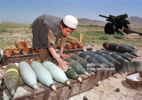 An Afghan boy cleans artillery rounds at Hussain Kot on the frontline ...