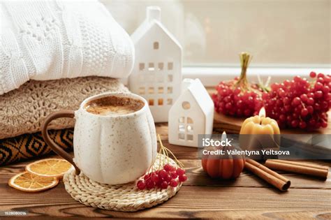가을 작곡 뜨거운 커피 한 잔 장식용 작은 집 호박 양초 책 나무 테이블에 따뜻한 스웨터 계절에 따라 따뜻한 아침 커피 아늑한 인테리어 장식 가을에 대한 스톡 사진 및 기타