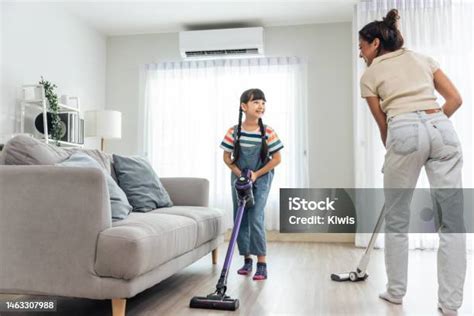 백인 아름 다운 어머니는 어린 아이 딸과 함께 집을 청소합니다 매력적인 아름다운 엄마는 집안일과 집안일을 위해 지저분한 더러운 바닥을 진공 청소기로 청소하는 사랑스러운 소녀