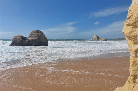 Premium Photo Rocky Sea Stacks On Sandy Beach With Waves Crashing