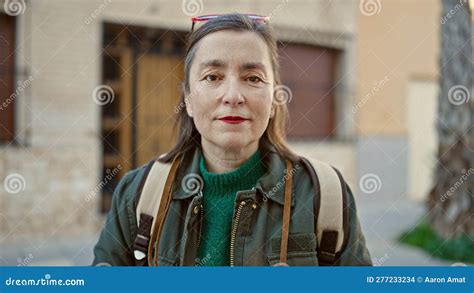 Mature Hispanic Woman With Grey Hair Tourist Wearing Backpack Looking