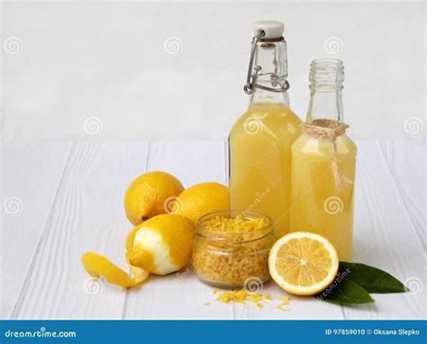 Freshly Squeezed Lemon Juice in Bottle and Lemons on Light Background. for Vitamin Drink or ...