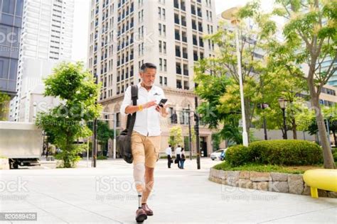 그의 휴대 전화를 사용 하 여 야외 캐주얼 수석 수족 사업가 절단 수술을 받은 사람에 대한 스톡 사진 및 기타 이미지 절단 수술을 받은 사람 걷기 일본 Istock