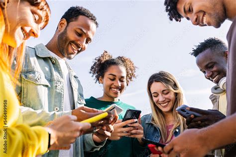 Young Group Of Happy Friends Using Smart Mobile Phone Together Outdoors Multiracial Teenage