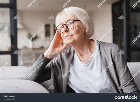 مادربزرگ پیرزن قفقازی سالخورده غمگین خسته و بیمار تنها ناامید نشسته روی