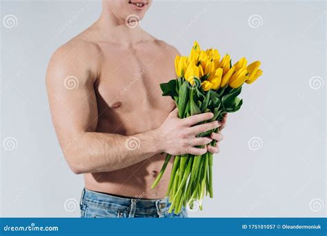 Человек с голым торсом дает цветы Романтический человек с букетом тюльпанов на день рождения